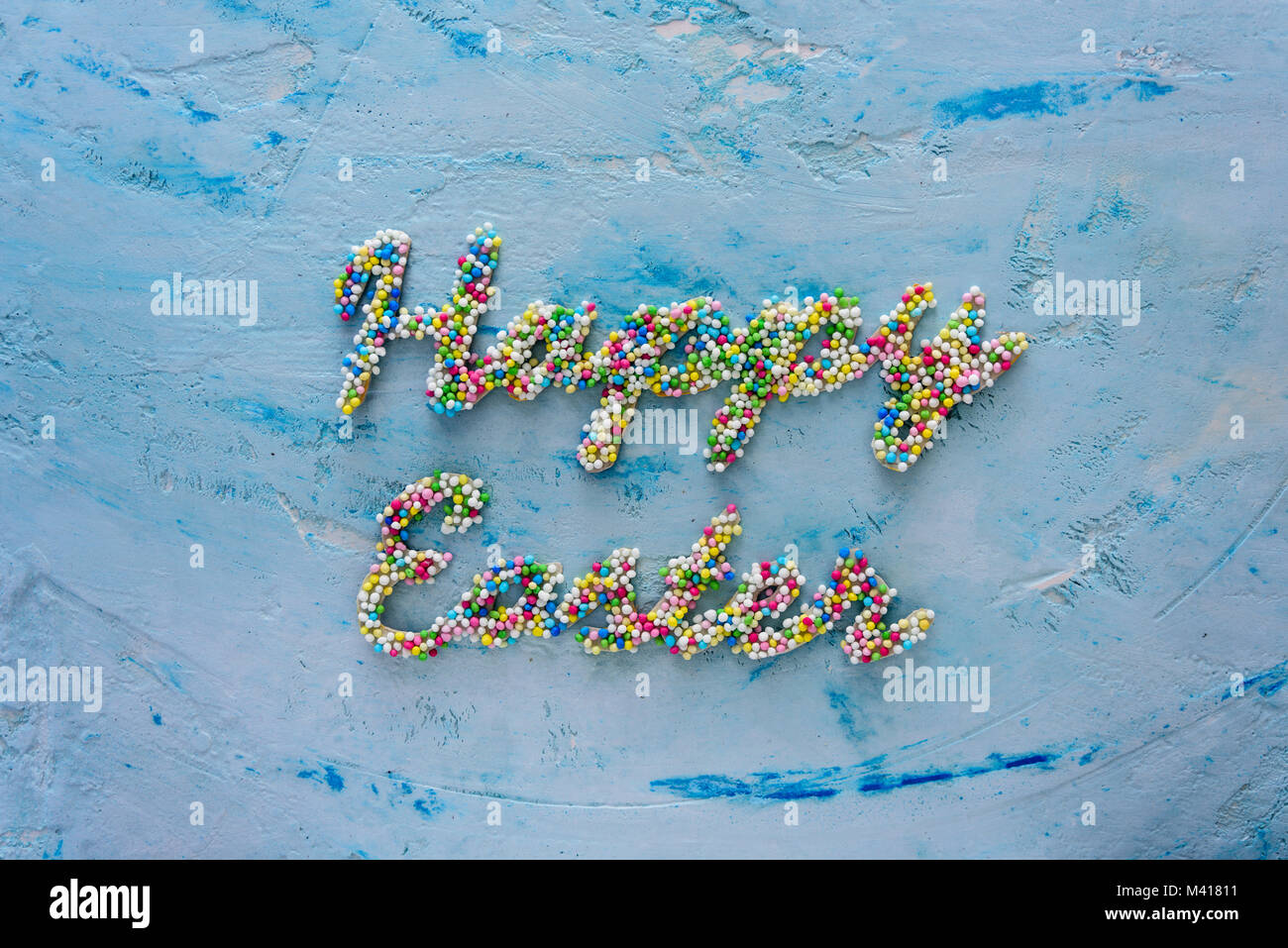 Words Happy Easter made of colorful candies on blue pastel background ...