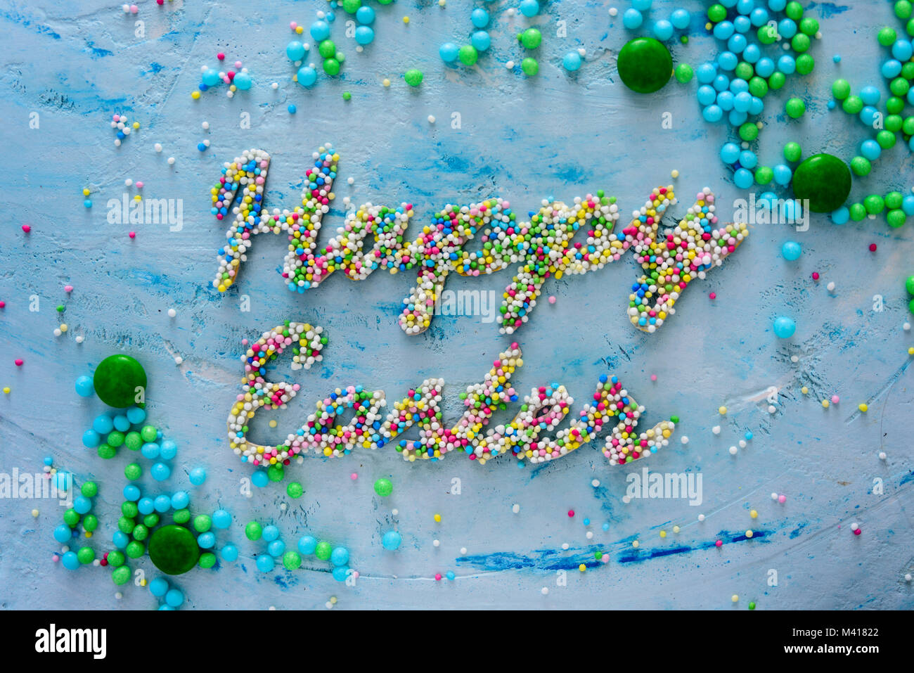 Words Happy Easter made of colorful candies on blue pastel background ...