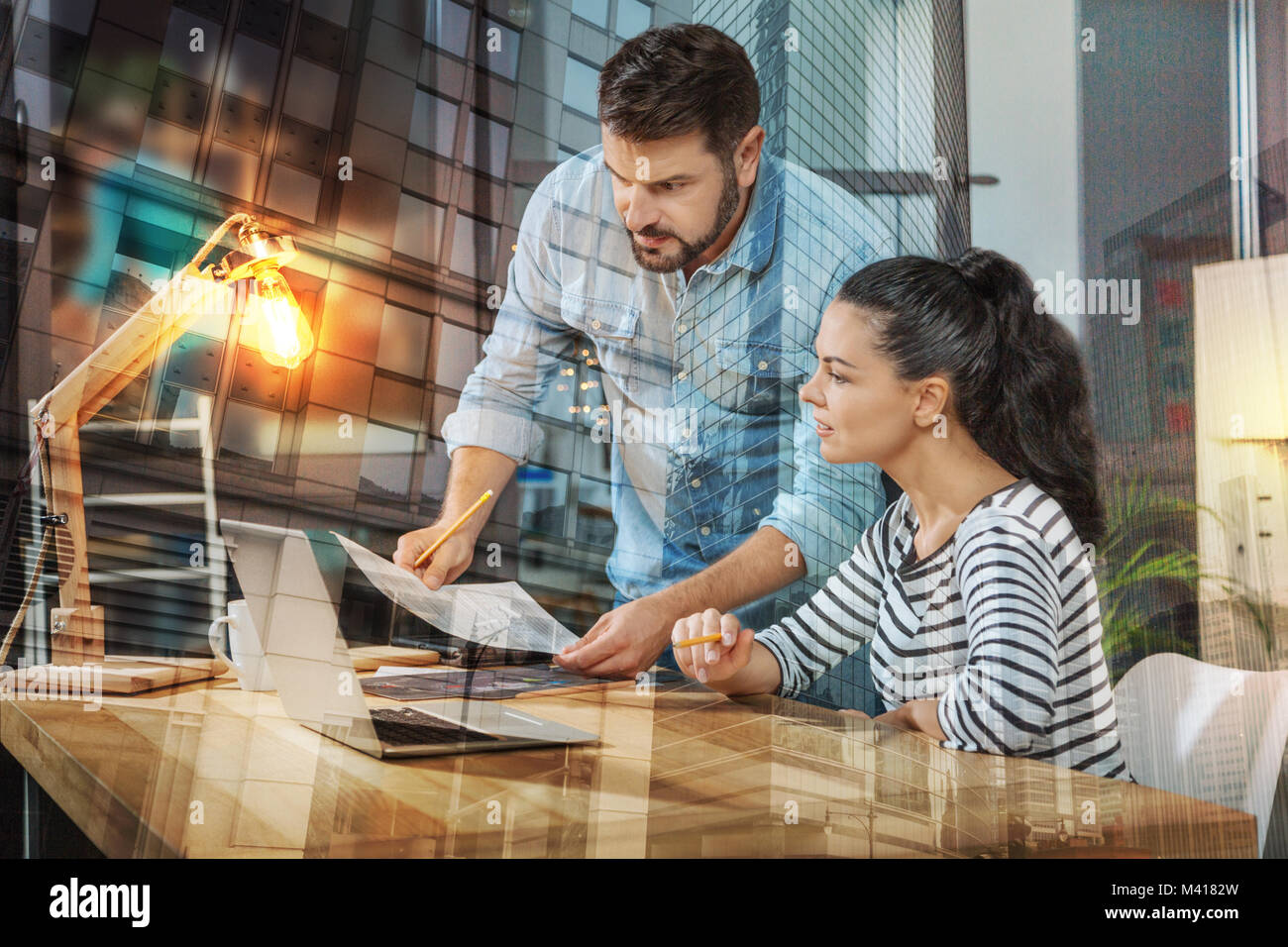 Smart colleagues looking at the screen while working together Stock ...
