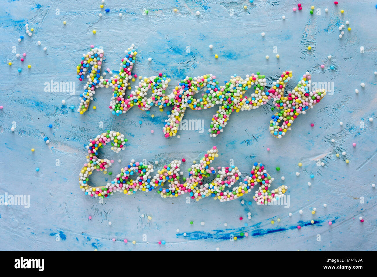 Words Happy Easter made of colorful candies on blue pastel background ...