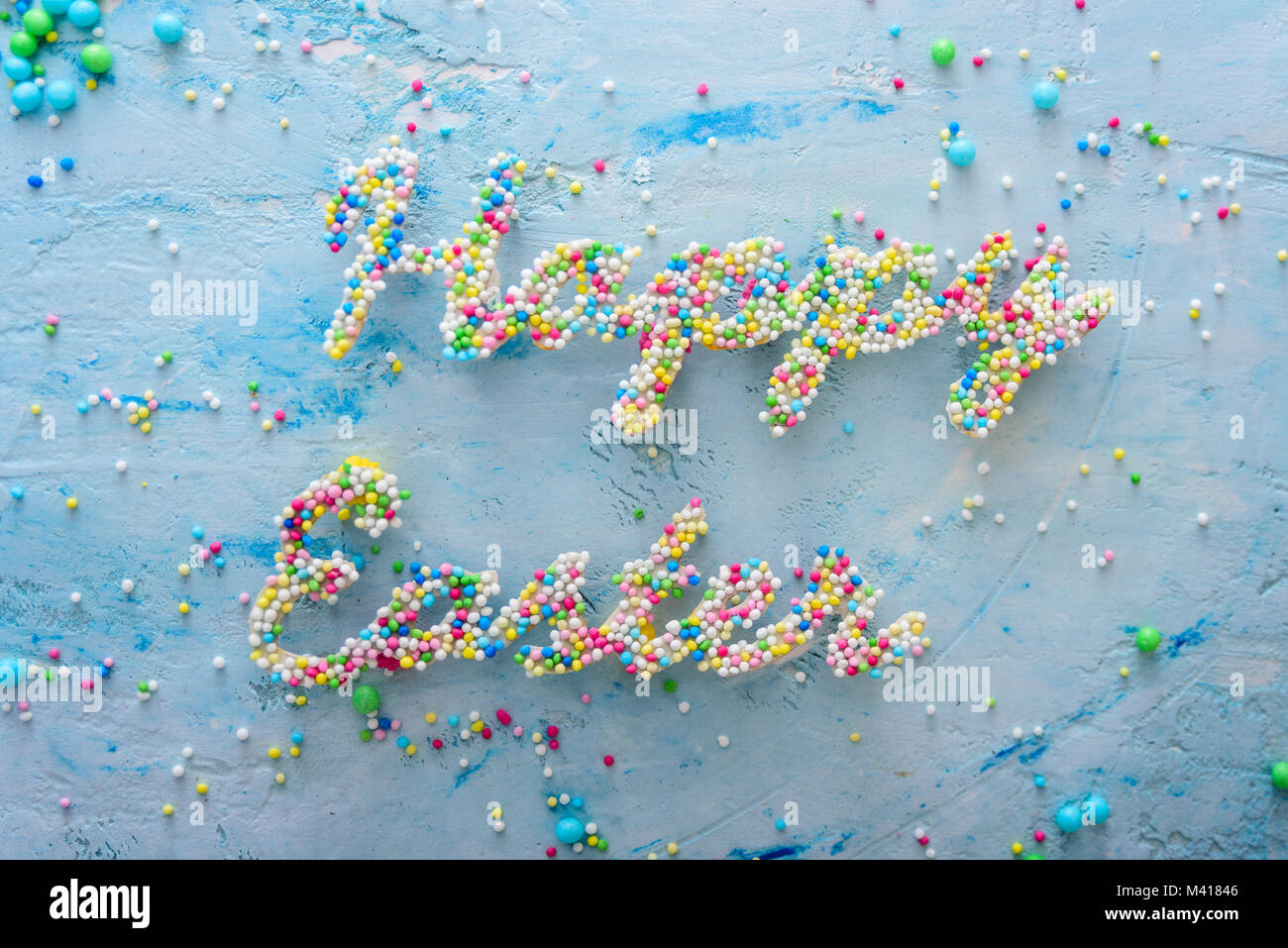 Words Happy Easter made of colorful candies on blue pastel background ...