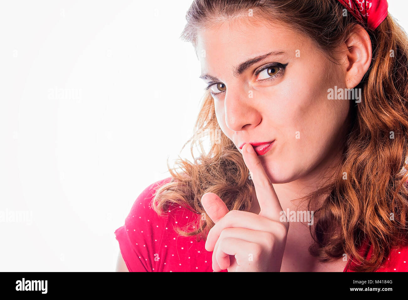 Lady in red with a finger on lips Stock Photo - Alamy