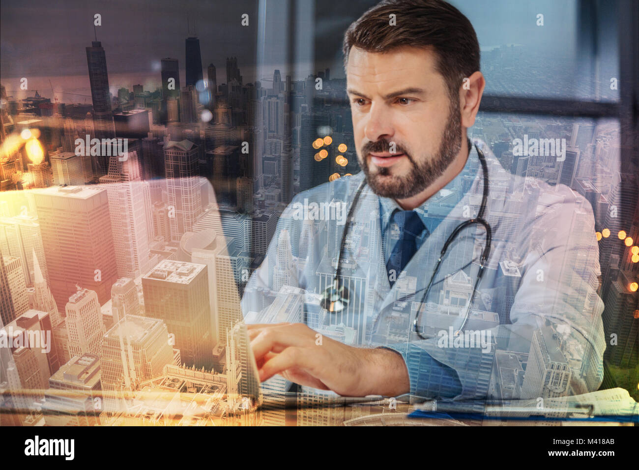 Clever doctor feeling interested while looking at the screen Stock ...