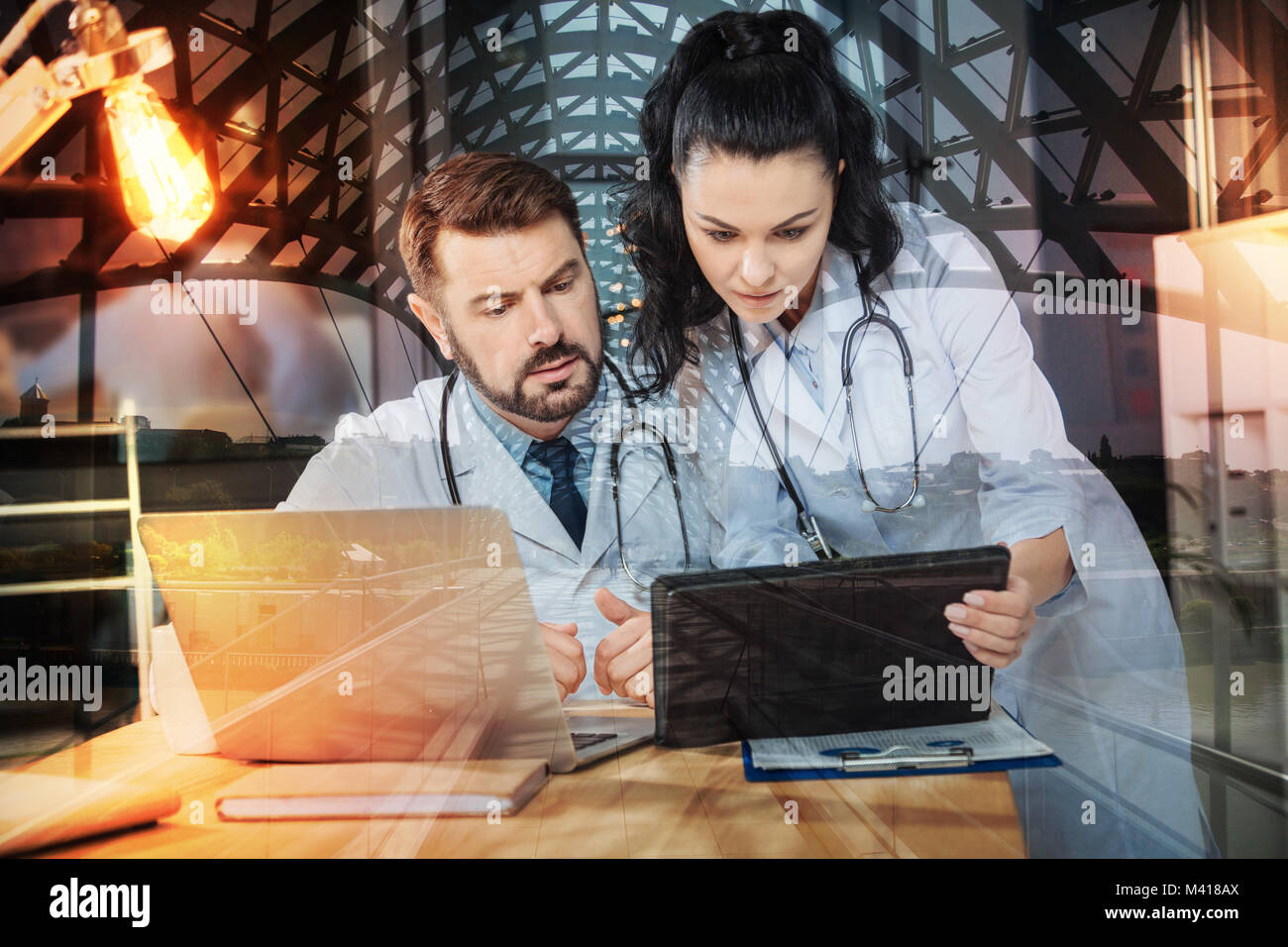 Smart doctors looking at the screen of a tablet and thinking Stock ...