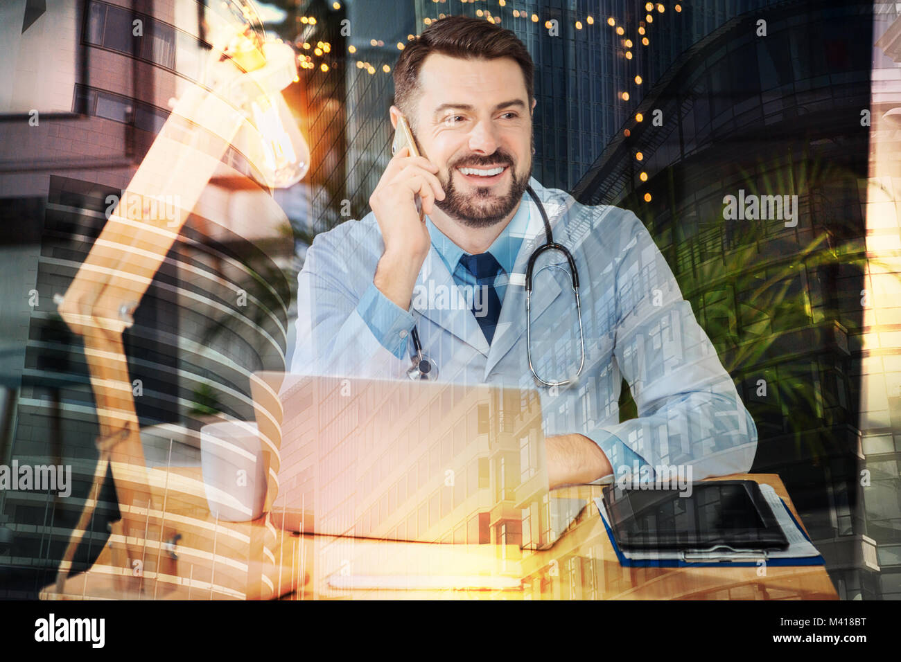 Happy doctor laughing while talking on the phone with a friend Stock ...