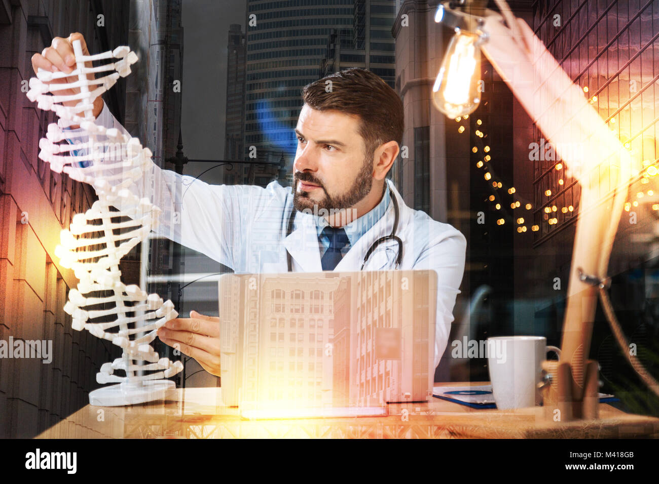 Smart geneticist holding a big DNA model while being at work Stock ...