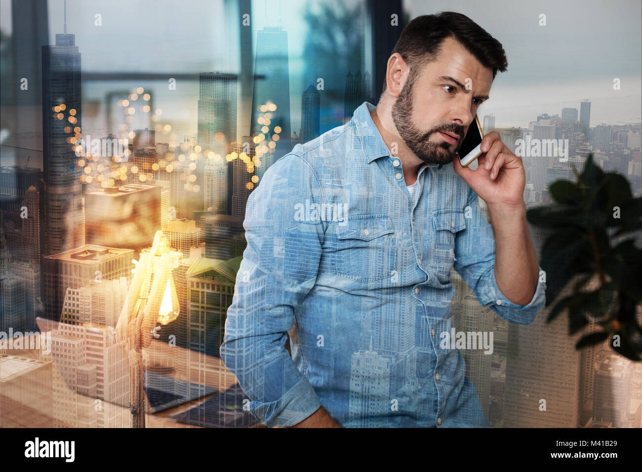 Concentrated man talking on phone Stock Photo - Alamy