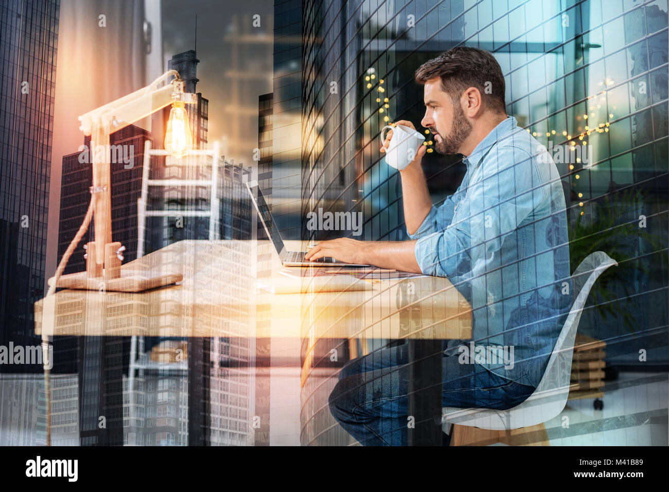 Thoughtful man looking at the screen while drinking coffee Stock Photo ...