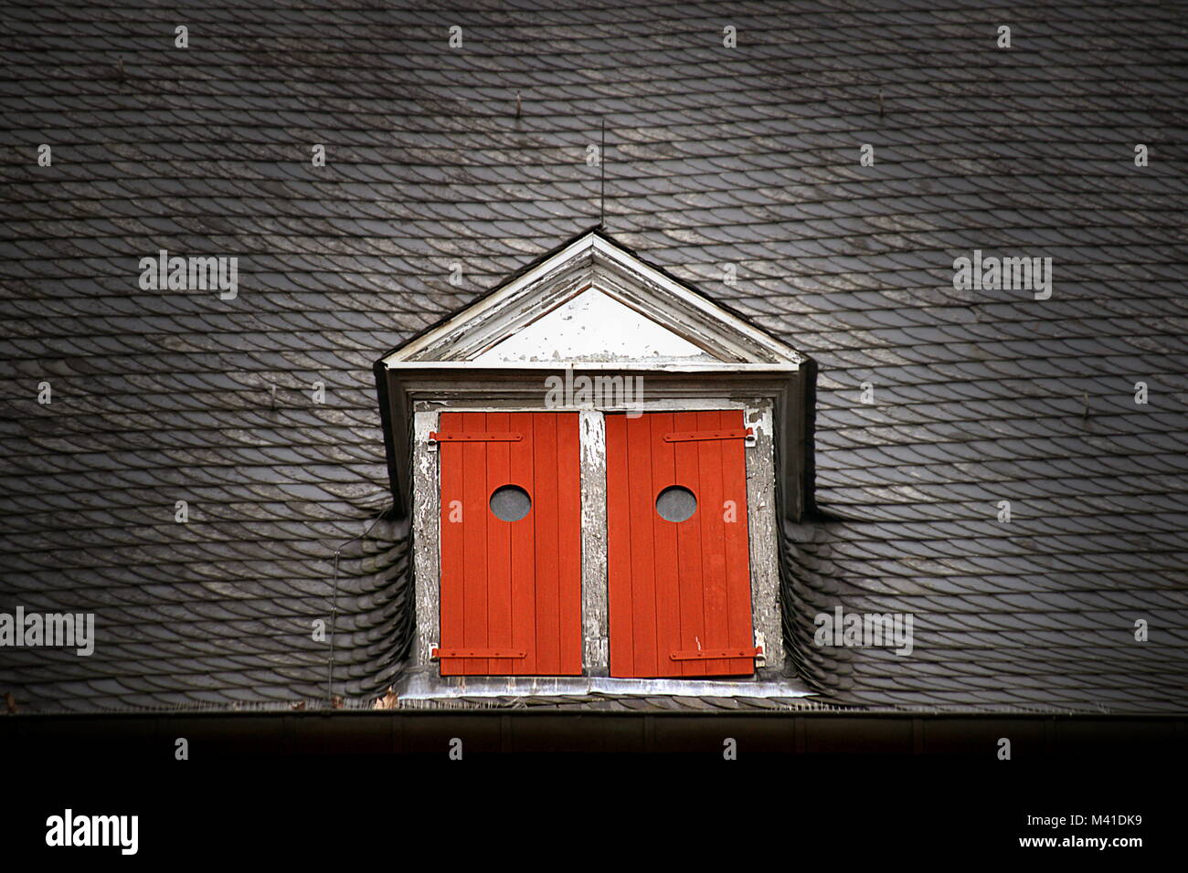 Close up of a dormer with red shutters on an old slate roof Stock Photo ...