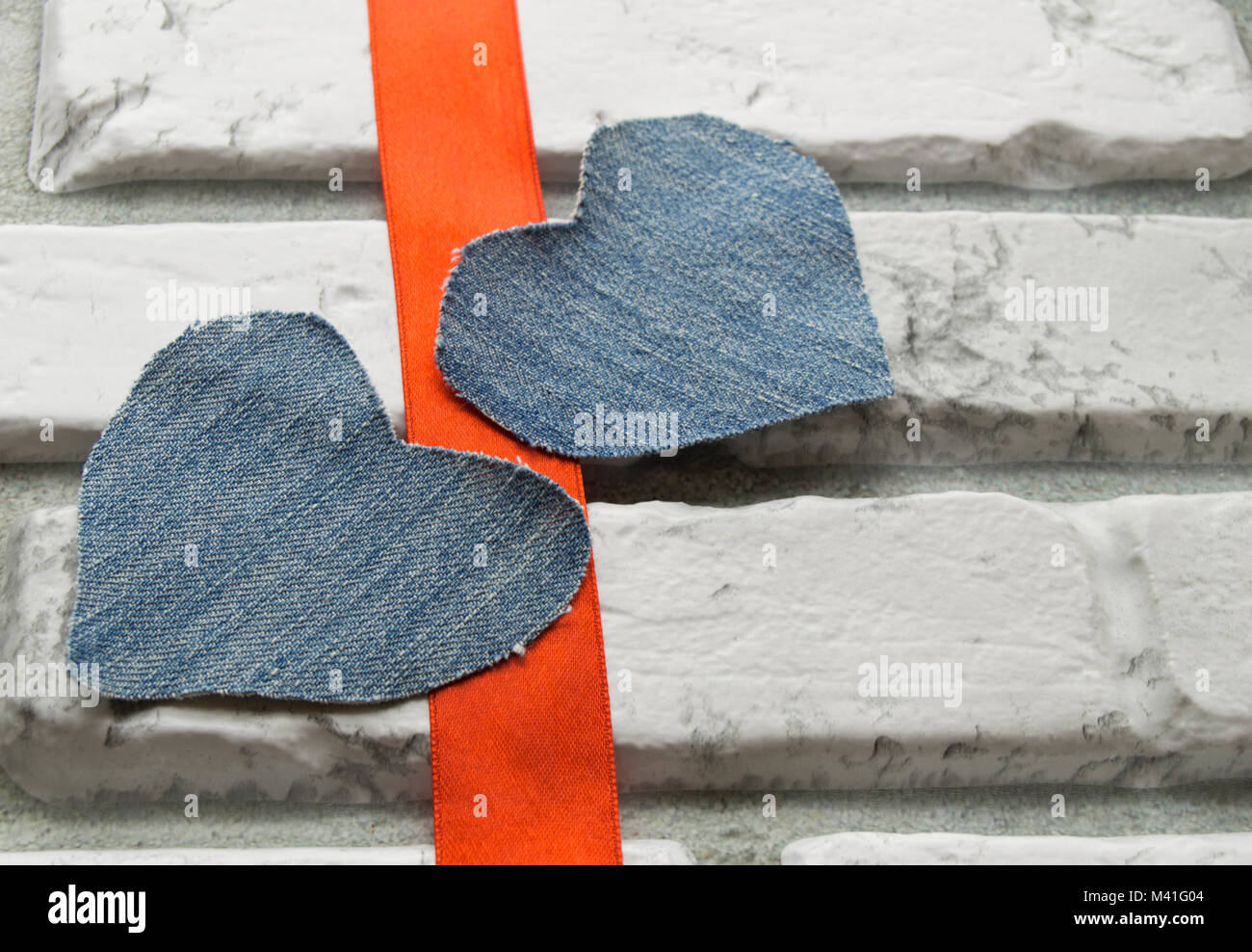 Two Denim hearts Valentine's Day background of white brick wall Stock ...