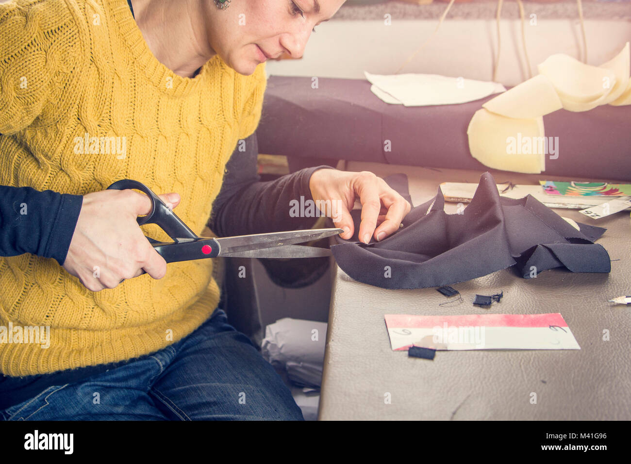Young tailor cutting clothing material Stock Photo - Alamy