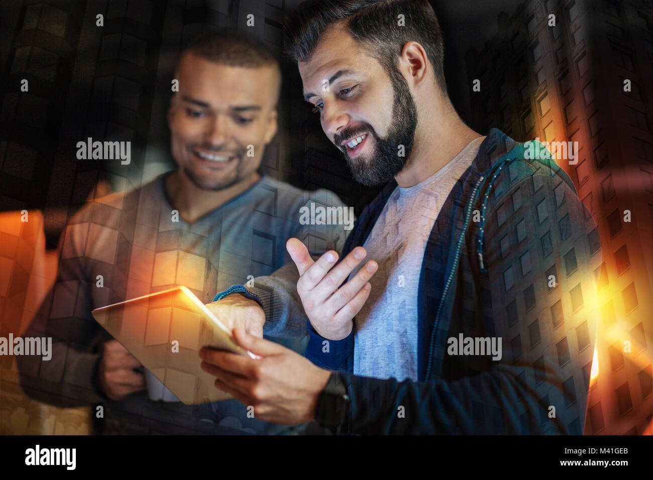 Smiling man pointing to the screen while looking at the photos Stock ...