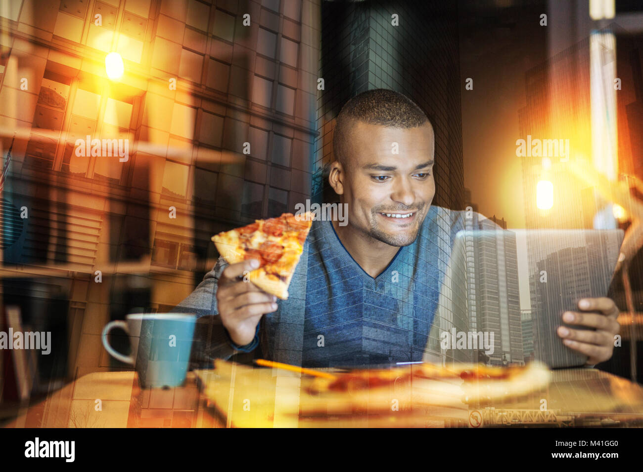 Smiling person eating tasty pizza and reading news on the screen Stock ...