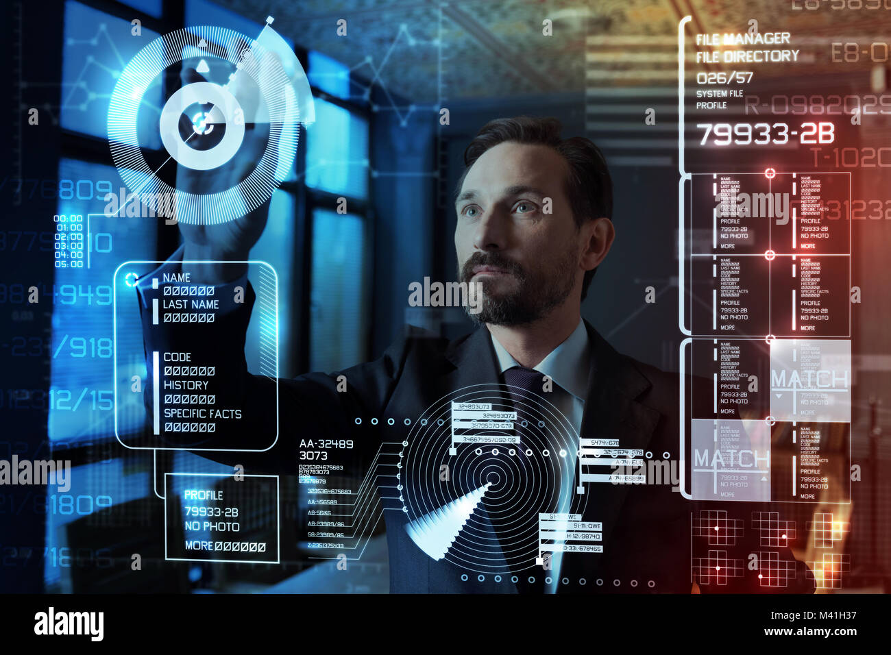 Attentive programmer looking at the information on a transparent screen ...