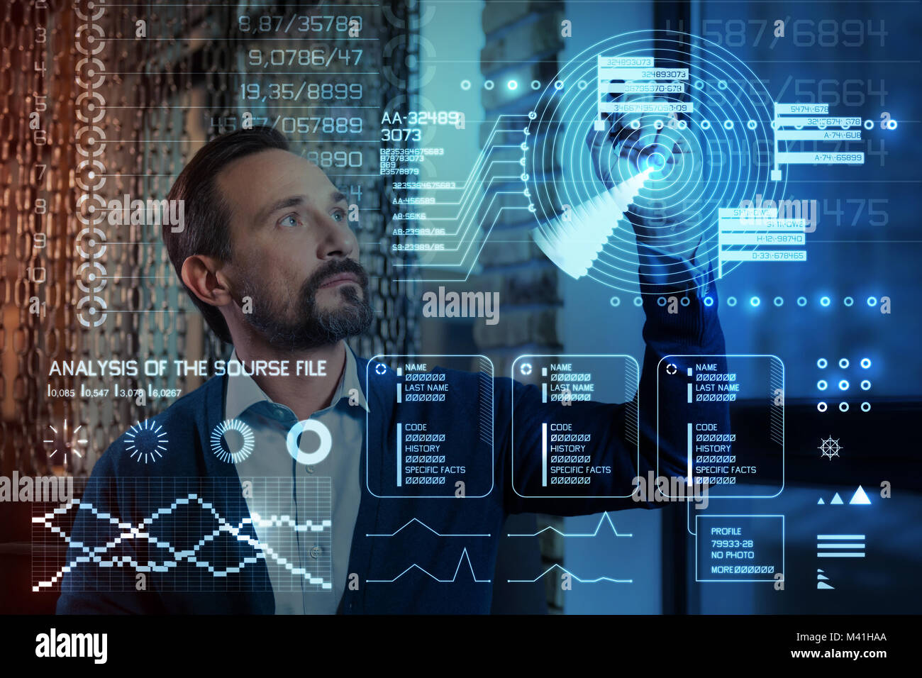 Calm man looking at the screen while touching it Stock Photo - Alamy