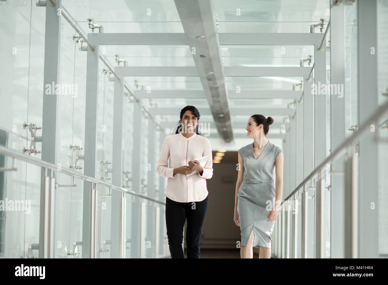 Business colleagues walking through office corridor Stock Photo - Alamy