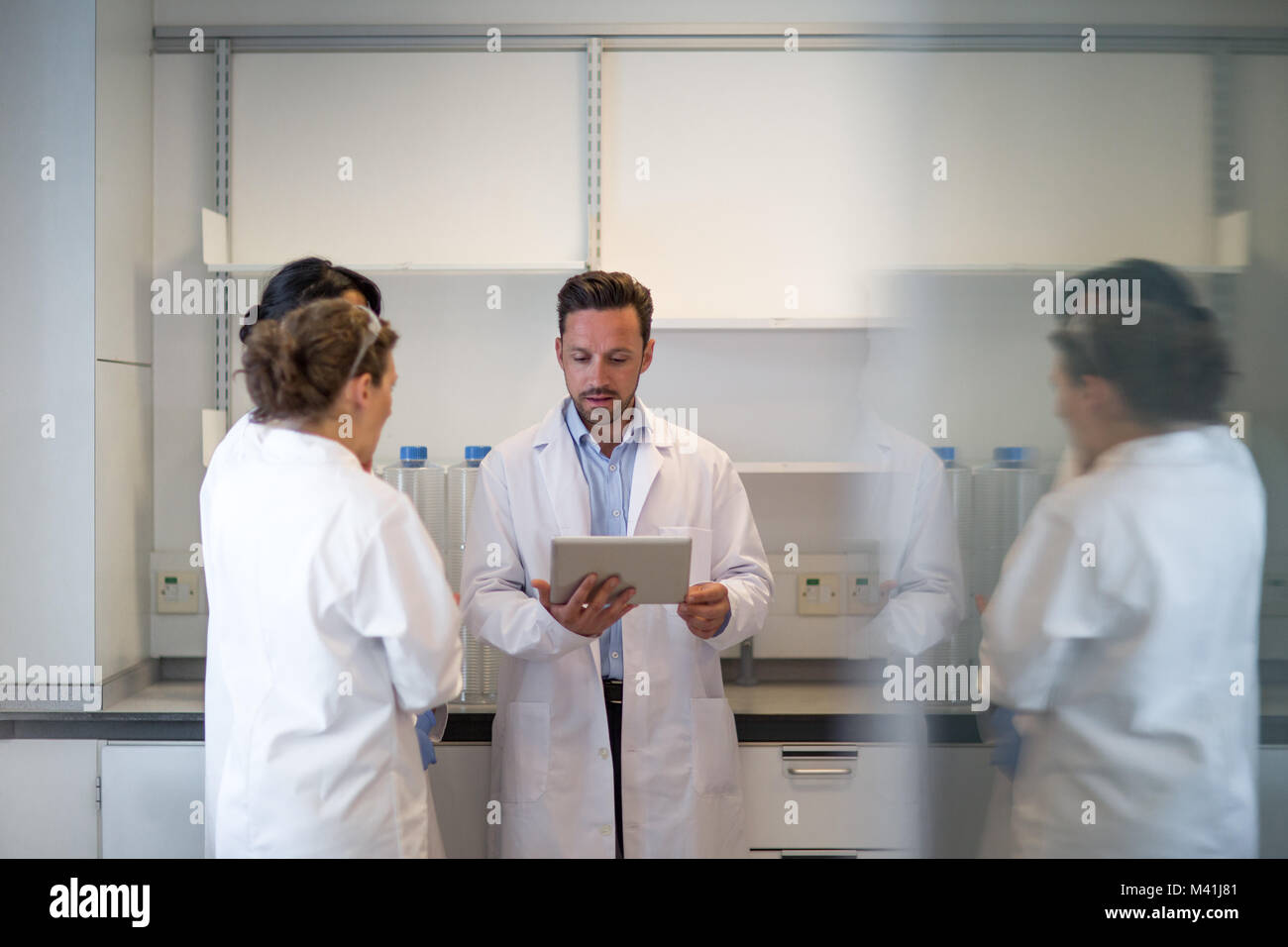 Team of scientists discussing experiment data on digital tablet Stock ... Team of scientists discussing experiment data on digital tablet Stock ...