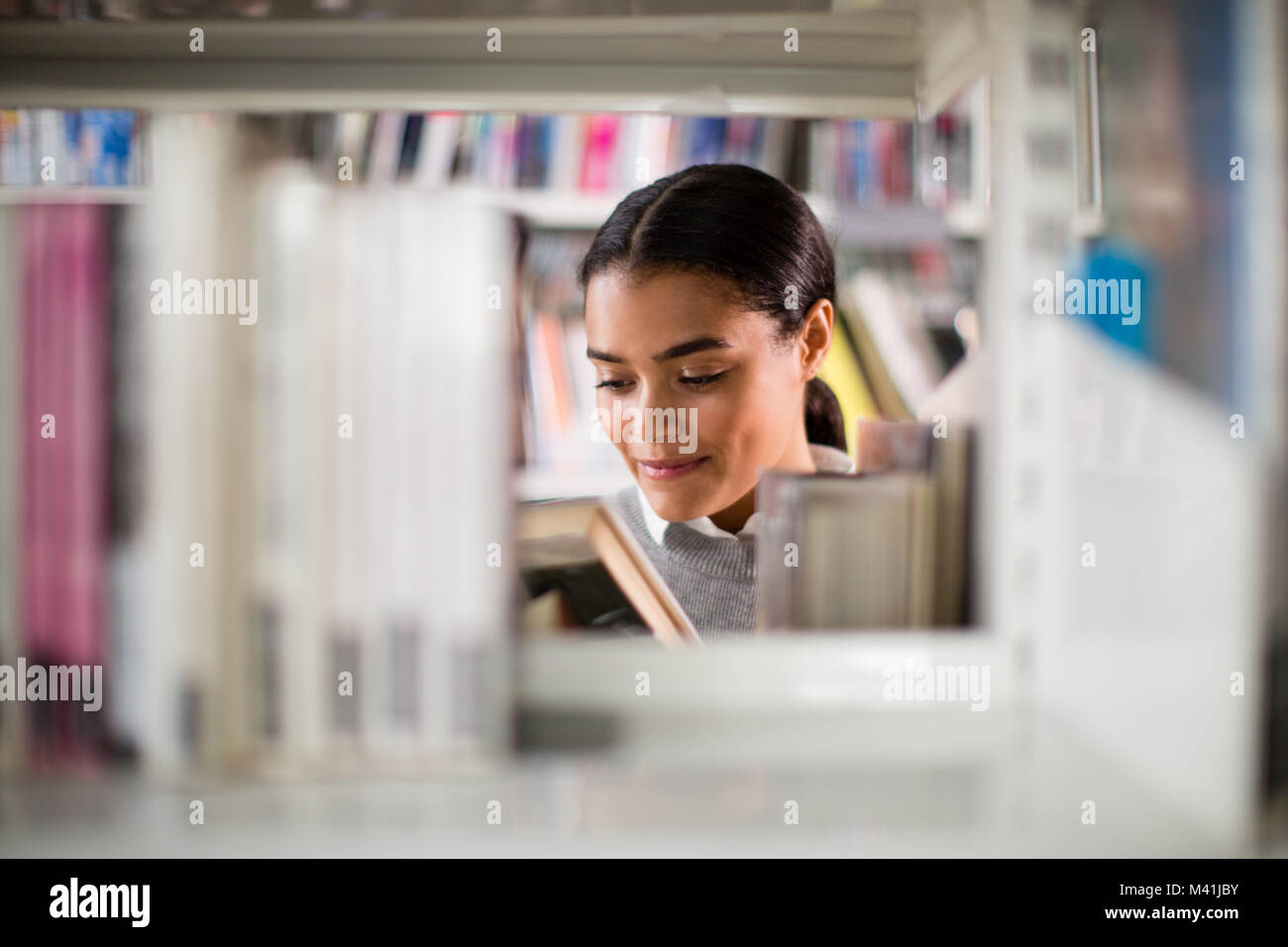 Student reading a book in library Stock Photo - Alamy