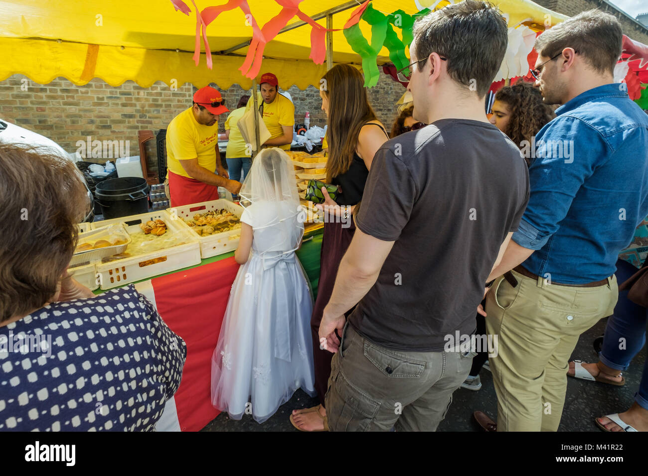 A first communicant in a white dress chooses a pastry at the Sagra ...