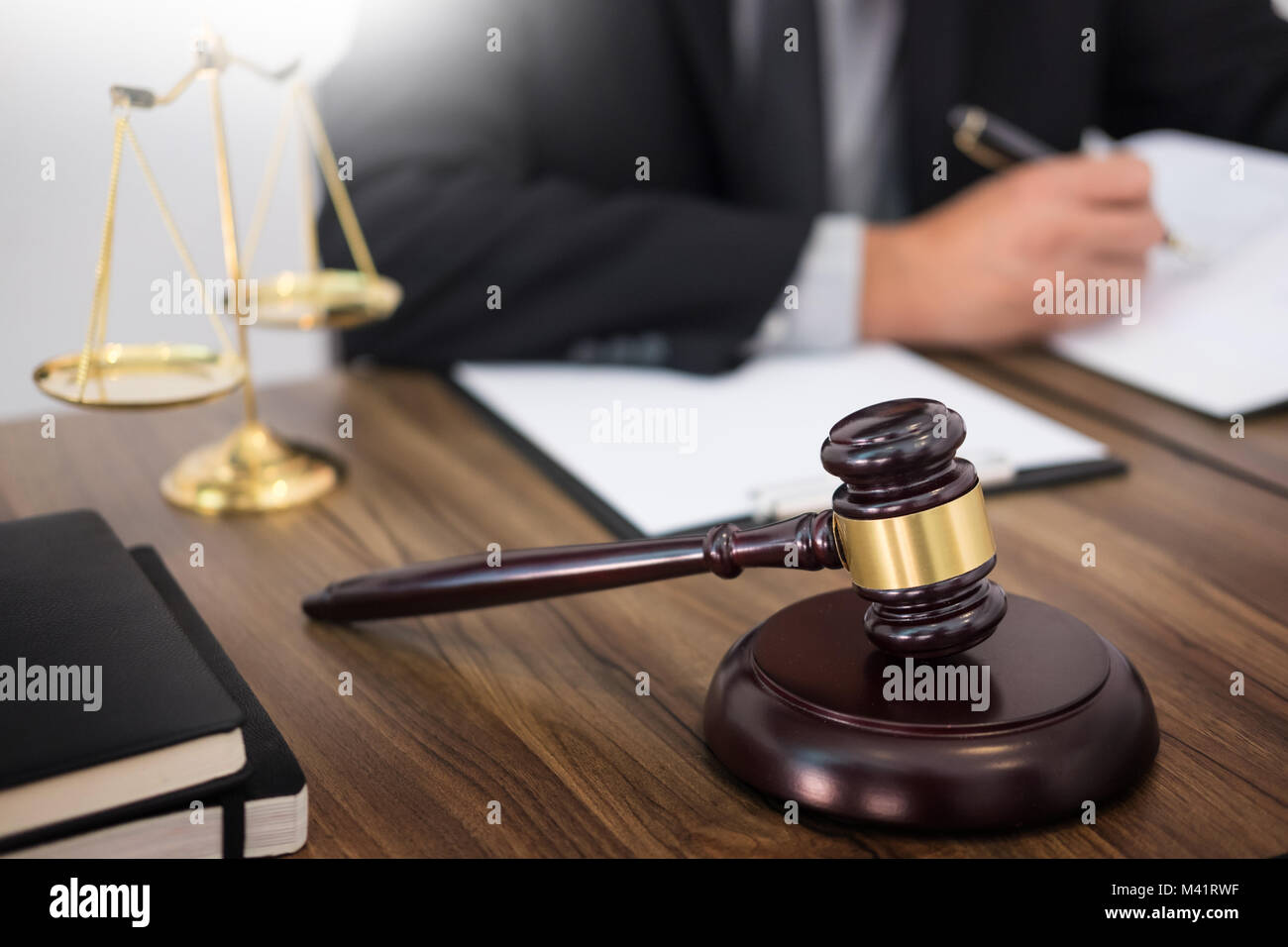 lawyer hand writes the document in court (justice, law) with sounding ...