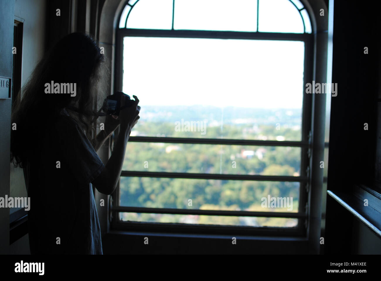Person taking a picture out of a high window Stock Photo - Alamy