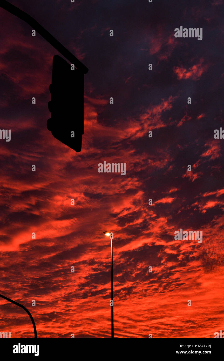 A streetlight and sign against the backdrop of a colorful sunset in ...