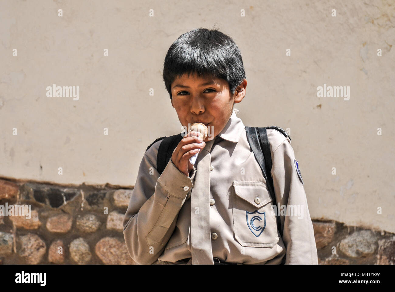 A young Peruvian boy wearing school uniform eating an ice cream Stock ...