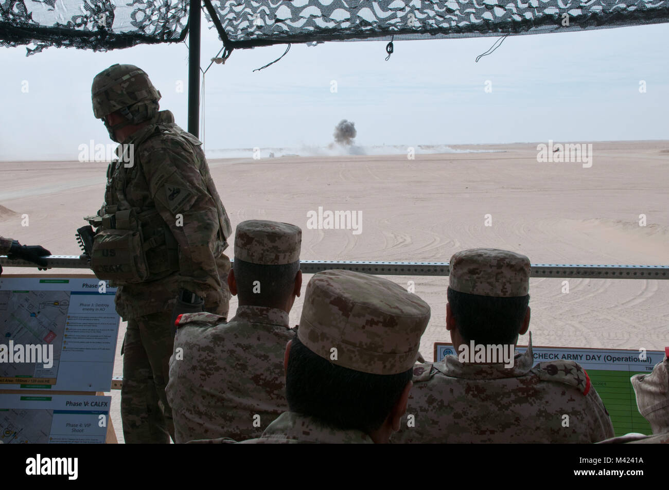 Kuwaiti and U.S. officers watch the explosion of two Bangalore ...