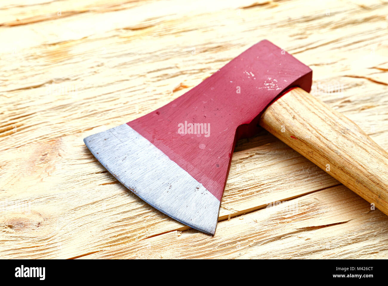 Red ax on a wooden background, top view Stock Photo - Alamy