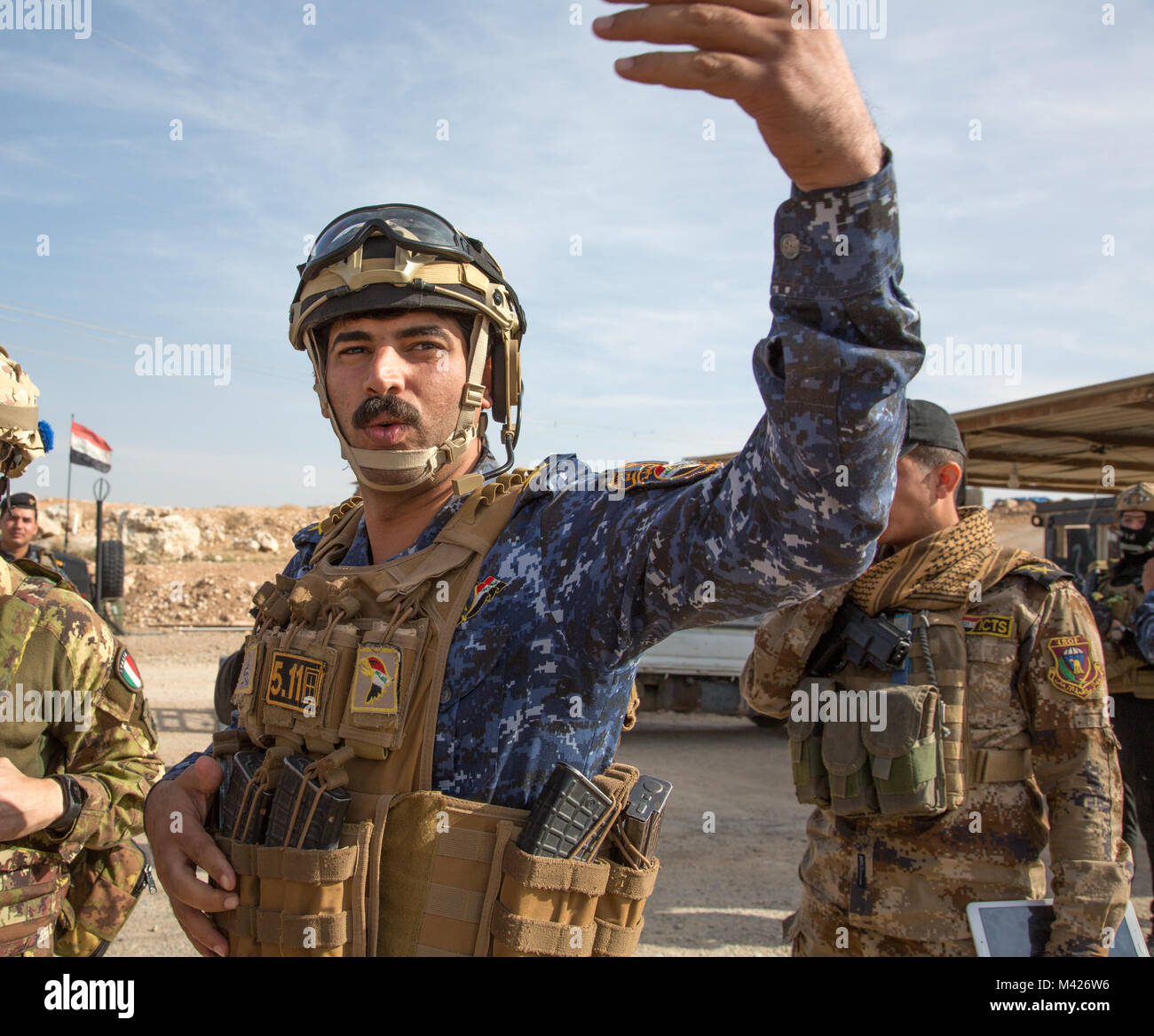 An Iraqi federal police officer manages traffic near Aski Mosul, Iraq ...