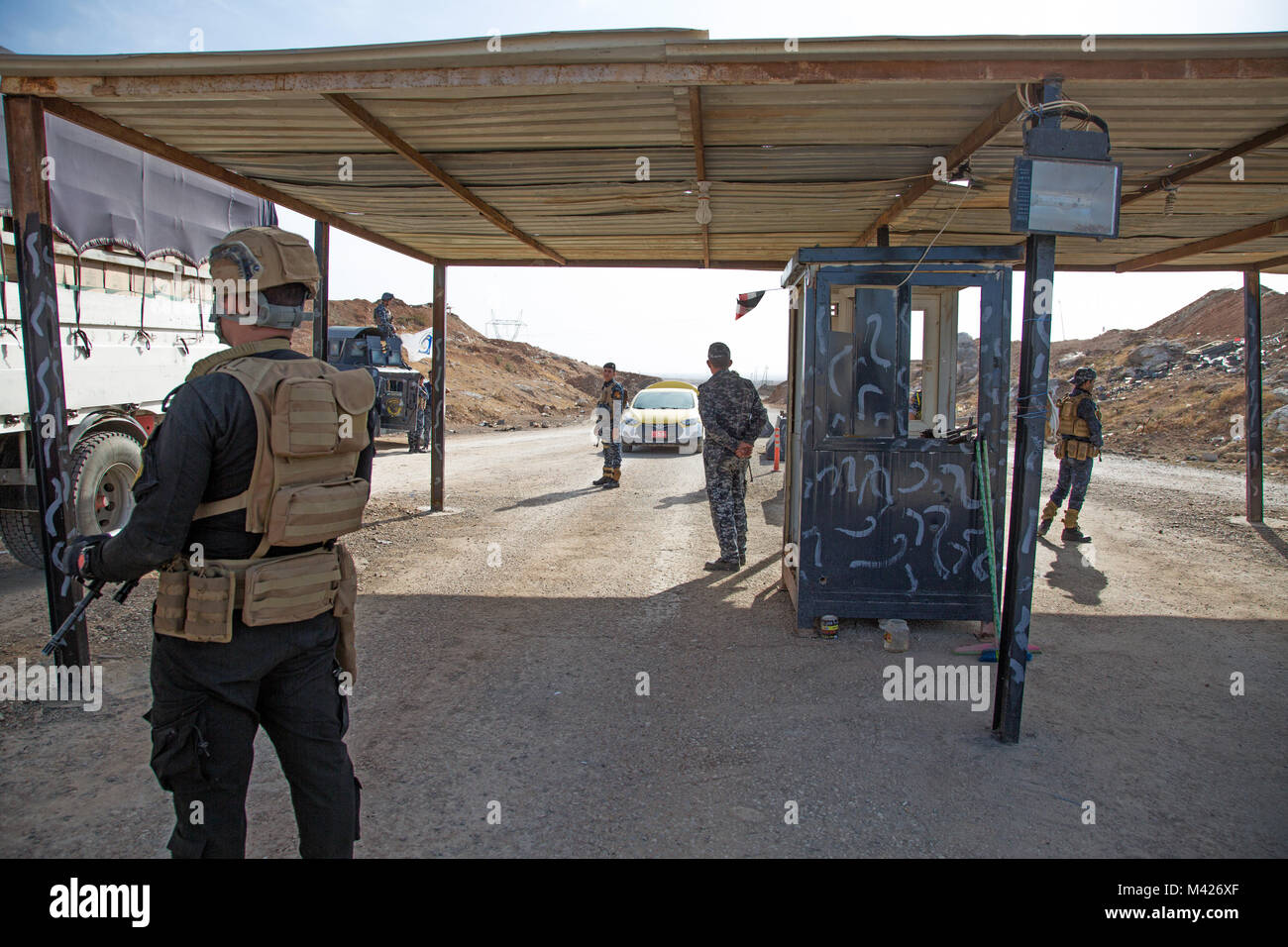 Iraqi security forces members provides security at a checkpoint near ...