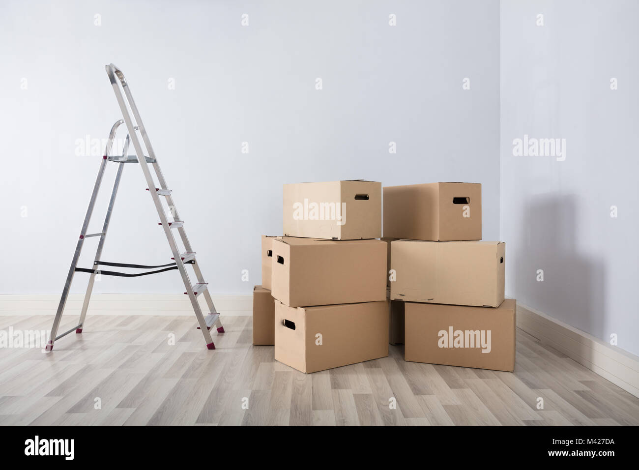 Stack Of Boxes In New House With Ladder Stock Photo - Alamy