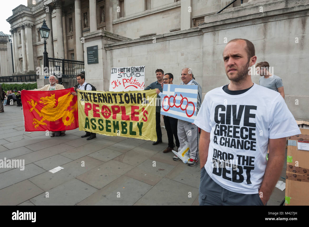 A toshirt 'Give Greece a chance - Drop the Debt' and a poster 'It's NOT ...