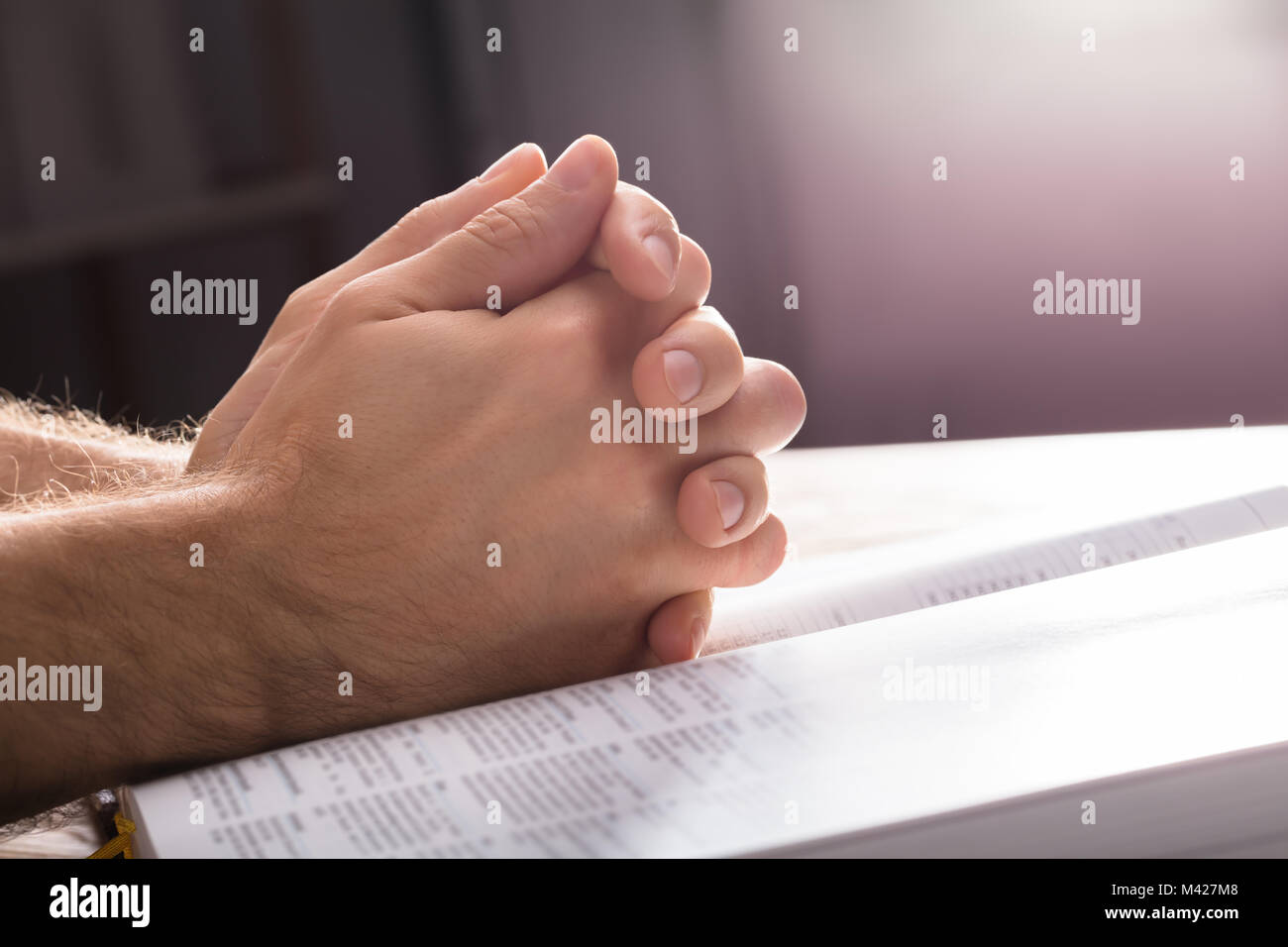 Close-up Of Man's Praying Hands Over The Bible Stock Photo - Alamy