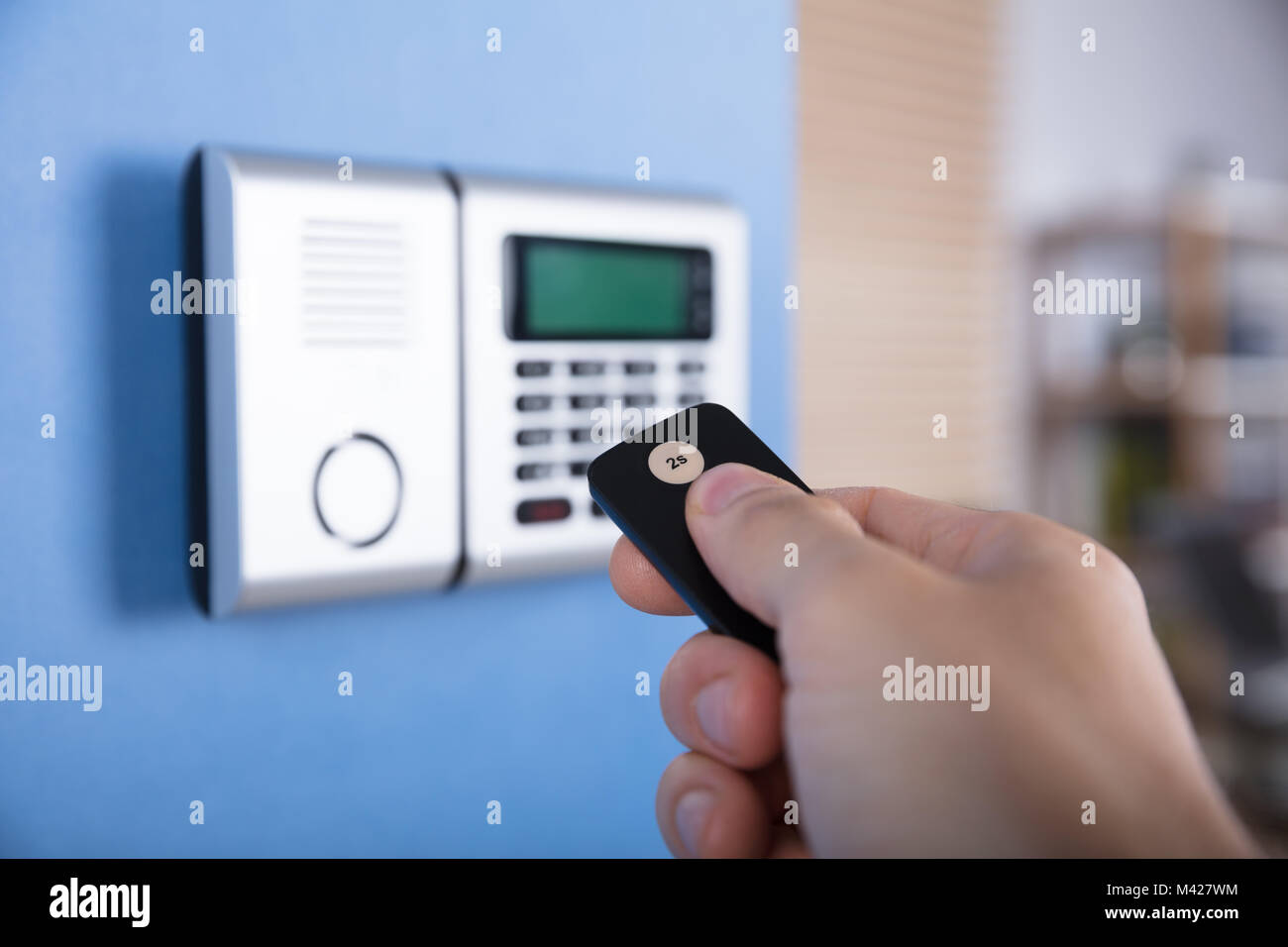 Close-up Of Person Hand Using Remote Control In Front Of Security Alarm ...