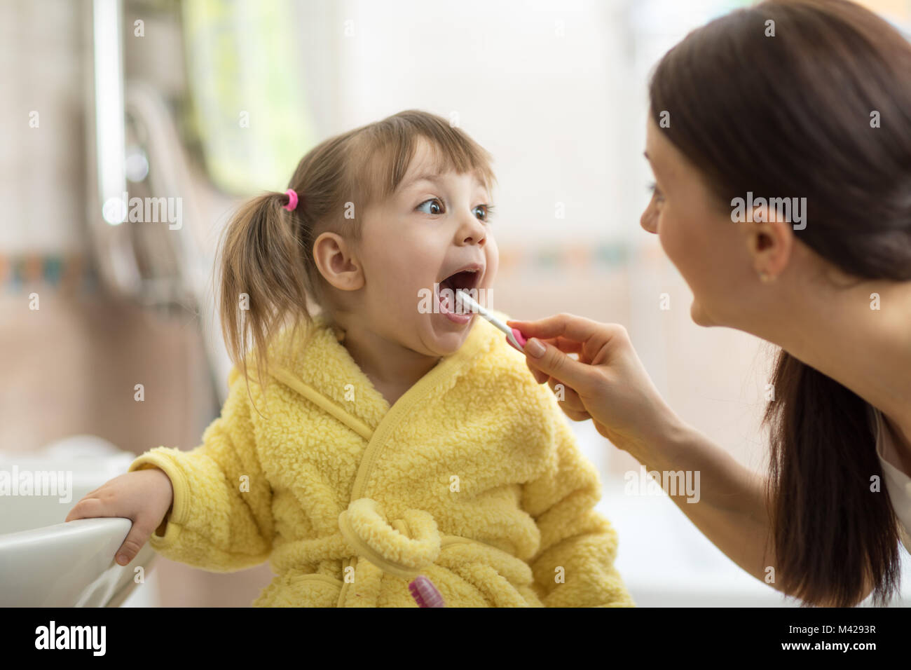 Mom brushing kid's teeth Stock Photo - Alamy