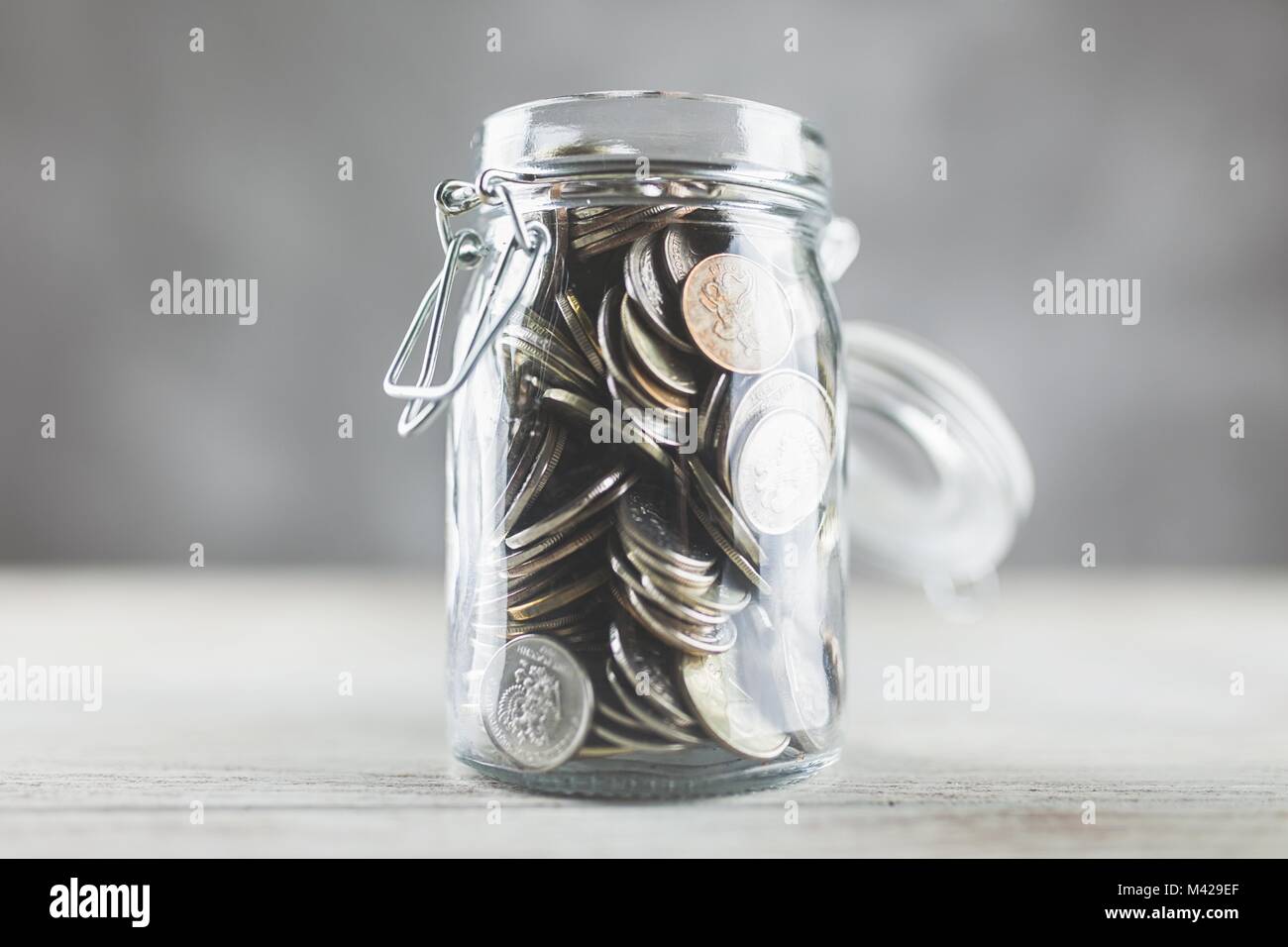 Coins in a glass jar Stock Photo - Alamy