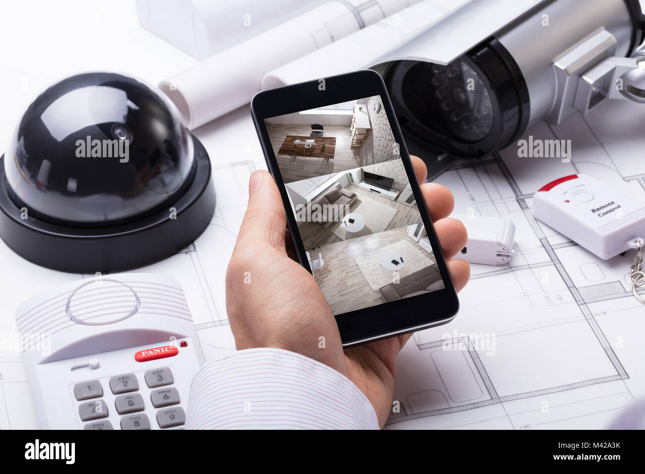 Person Hand Using Home Security System On Mobilephone With On Blueprint ...
