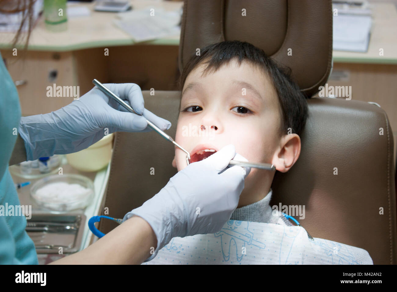Dentist is treating a boy's teeth Stock Photo - Alamy