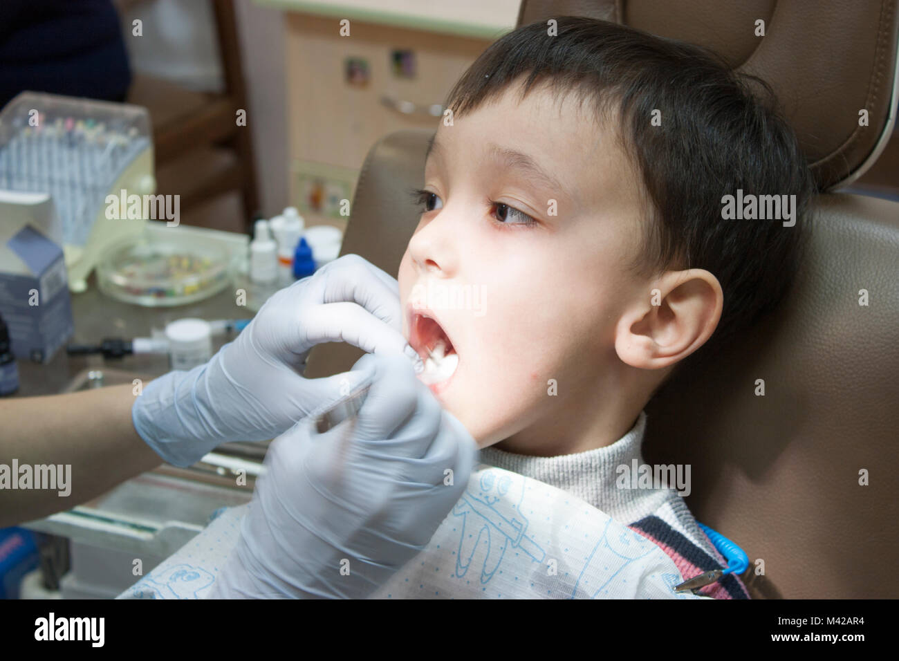 Dentist is treating a boy's teeth Stock Photo - Alamy