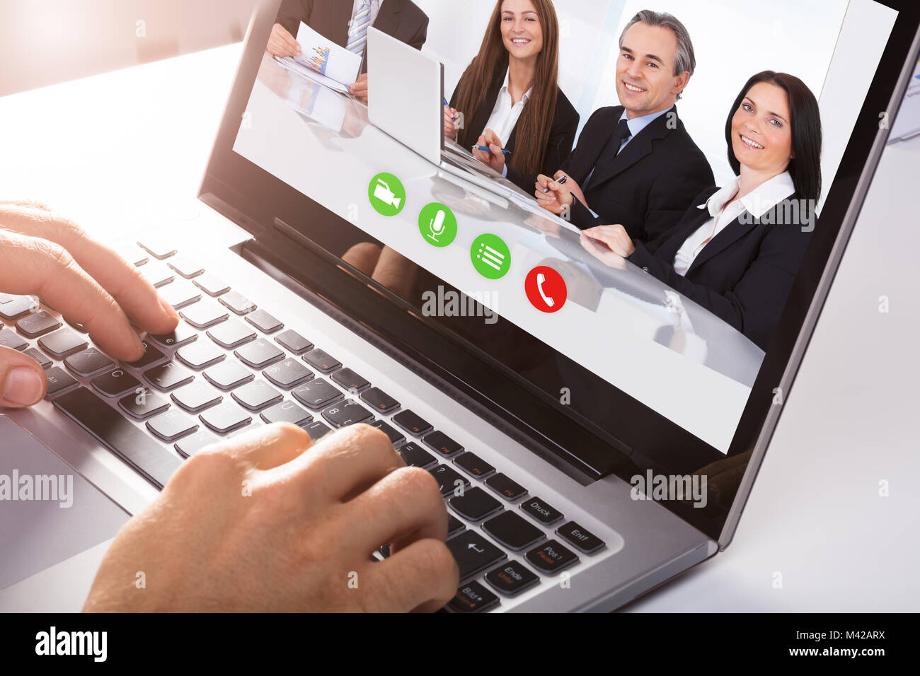 Close-up Of A Businessperson's Hand Video Conferencing With Male And ...