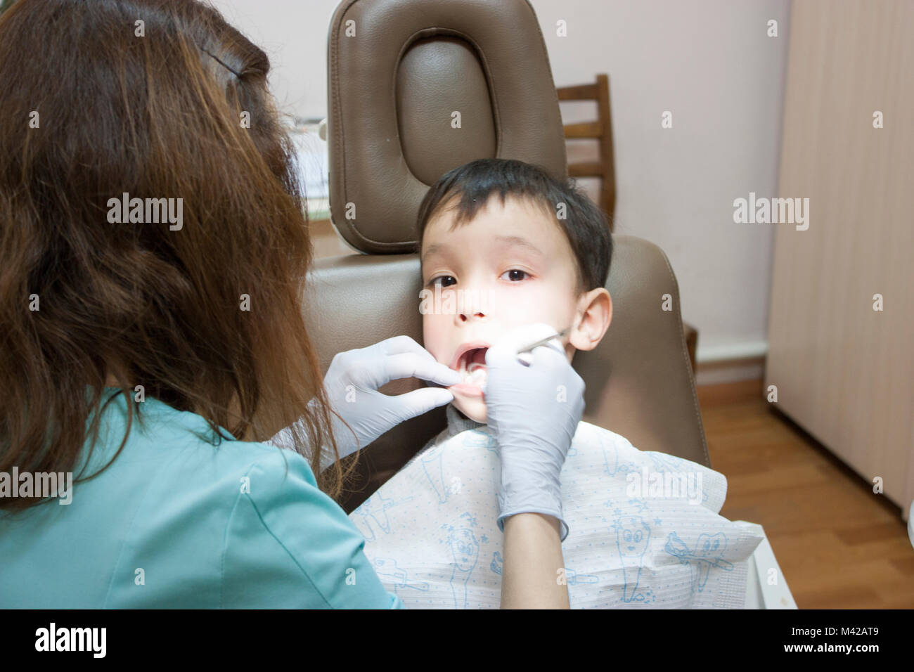 Dentist is treating a boy's teeth Stock Photo - Alamy