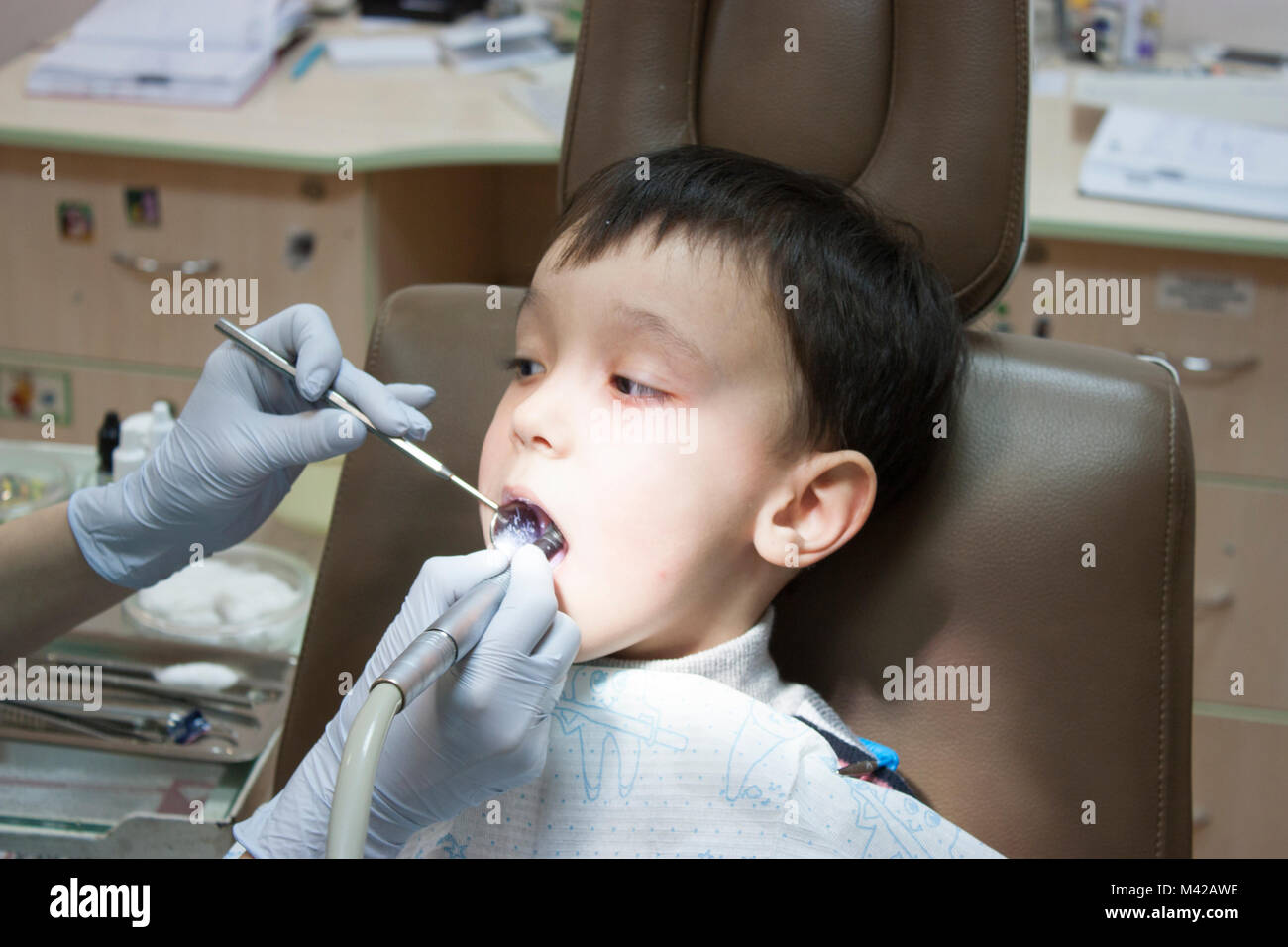Dentist is treating a boy's teeth Stock Photo - Alamy