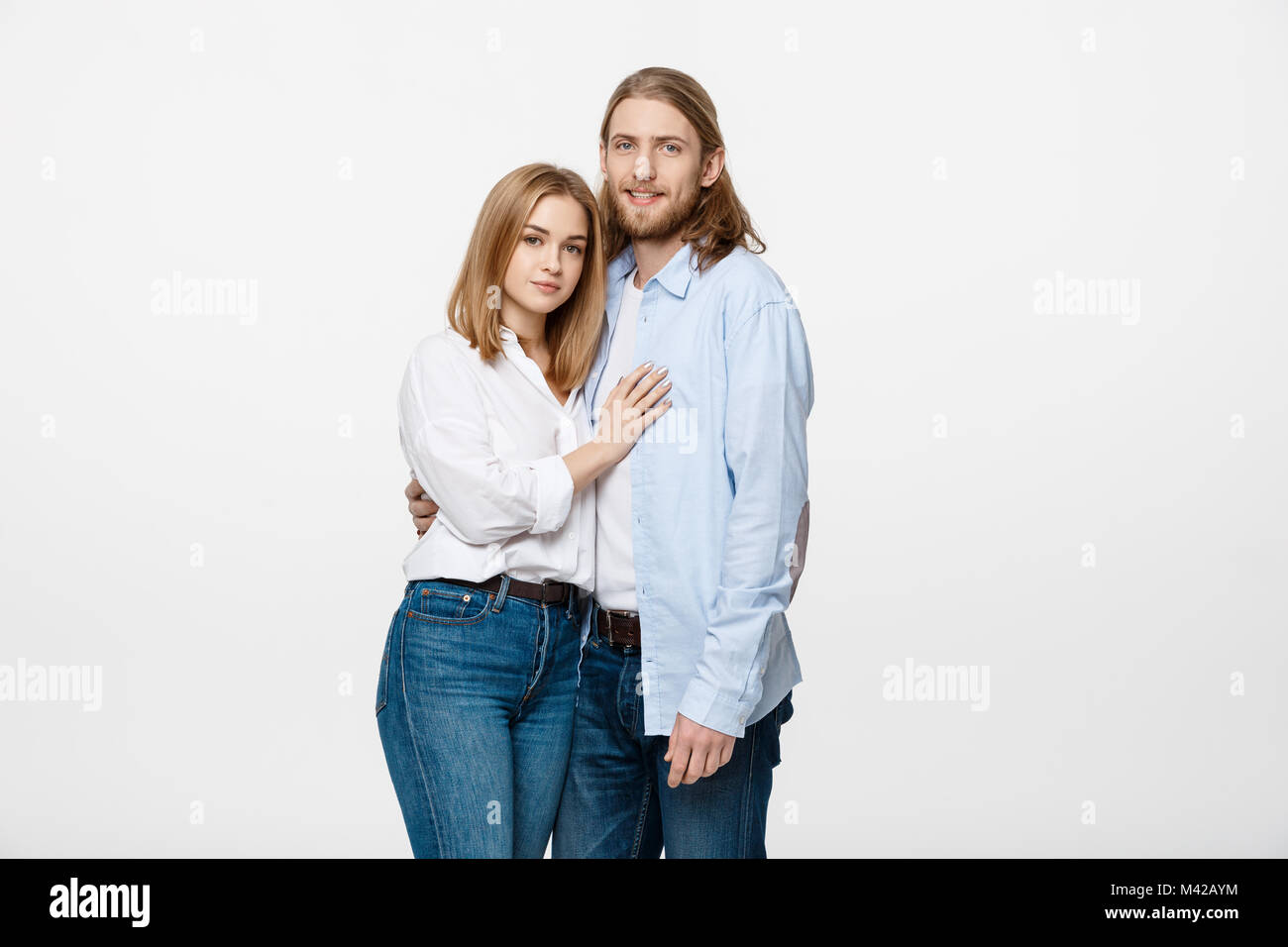 Portrait of cheerful young couple standing and hugging each other on ...