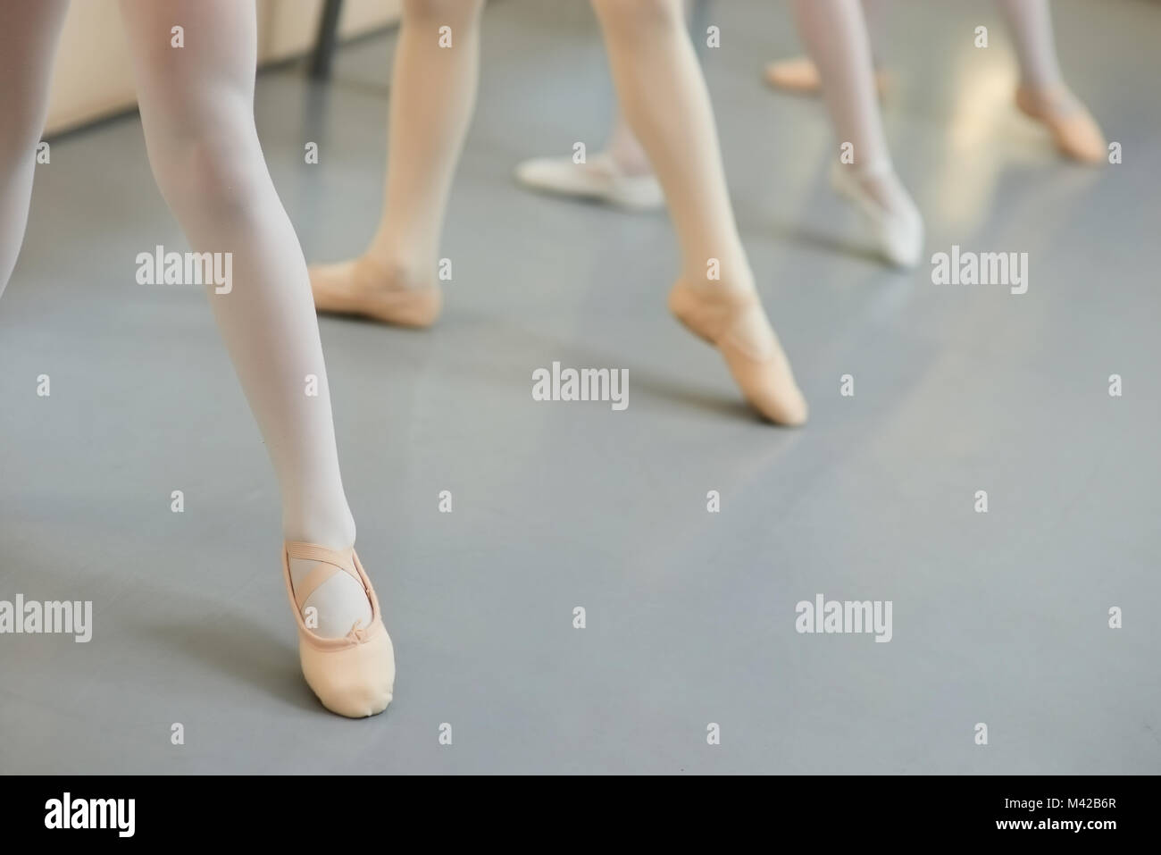 Legs of ballerinas in dance position. Young ballet dancers performing ...
