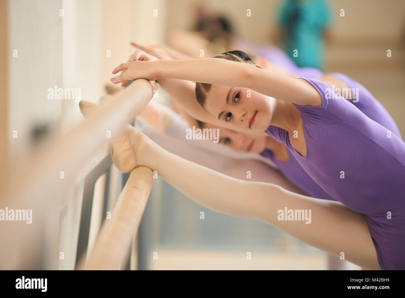 Young ballerina stretching before ballet practice. Ballet girl training ...