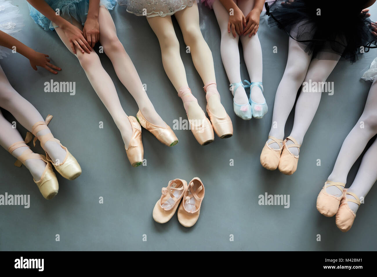Six ballerinas on the floor, top view. Ballet pointe shoes for little ...
