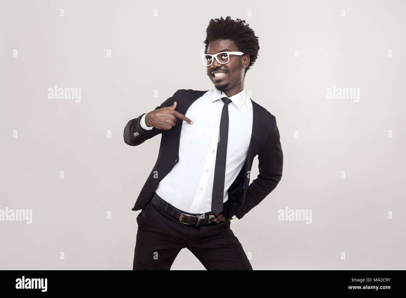 Well dressed proud man pointing finger himself. Studio shot, gray ...