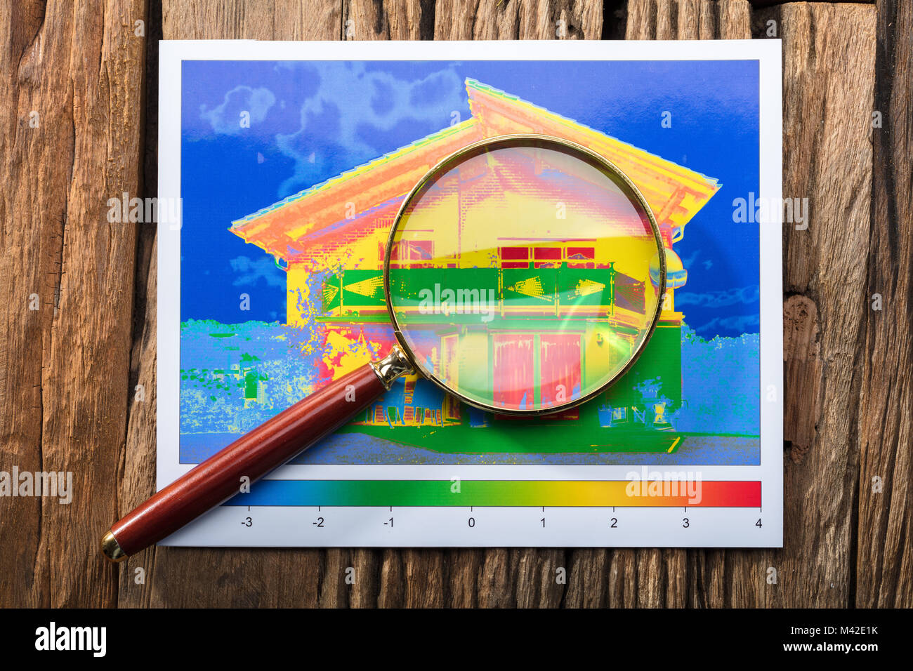 Close up Of Magnifying Glass On Heat Loss Efficiency Of A House Over close-up-of-magnifying-glass-on-heat-loss-efficiency-of-a-house-over