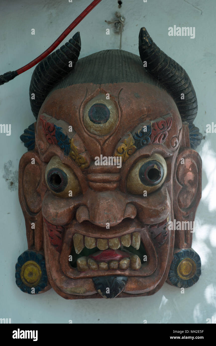 Wooden Tibetan old mask: a pink face with bulging eyes and huge fangs ...